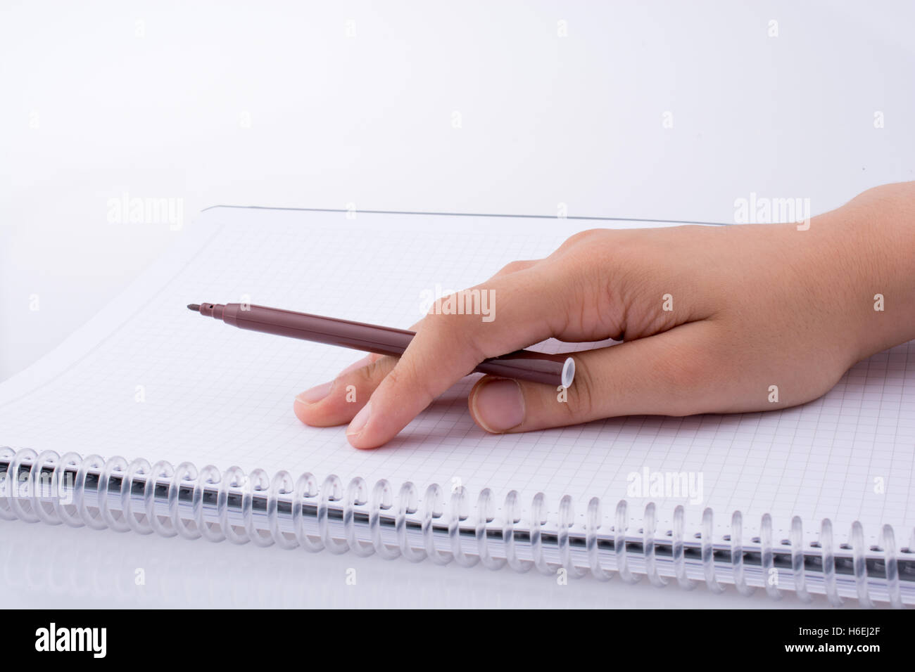 Hand writing on a Notebook with a pen on a white background Stock Photo ...