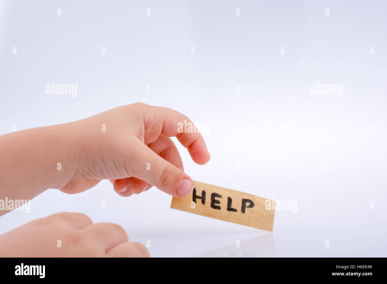 Help word on a piece paper in hand Stock Photo - Alamy