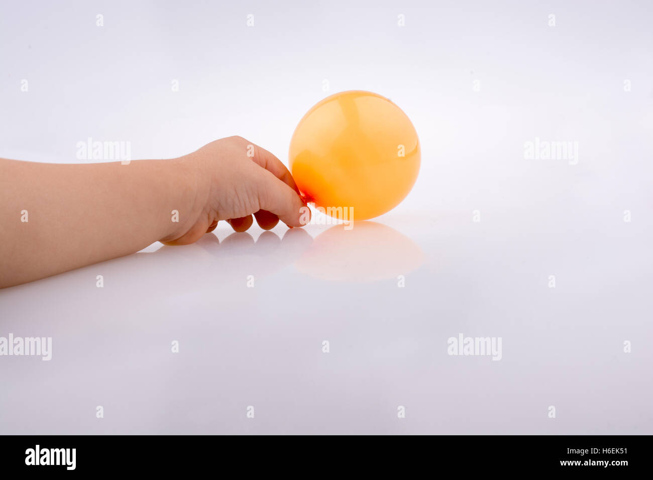 Hand holding a Colorful small balloon on a white background Stock Photo ...