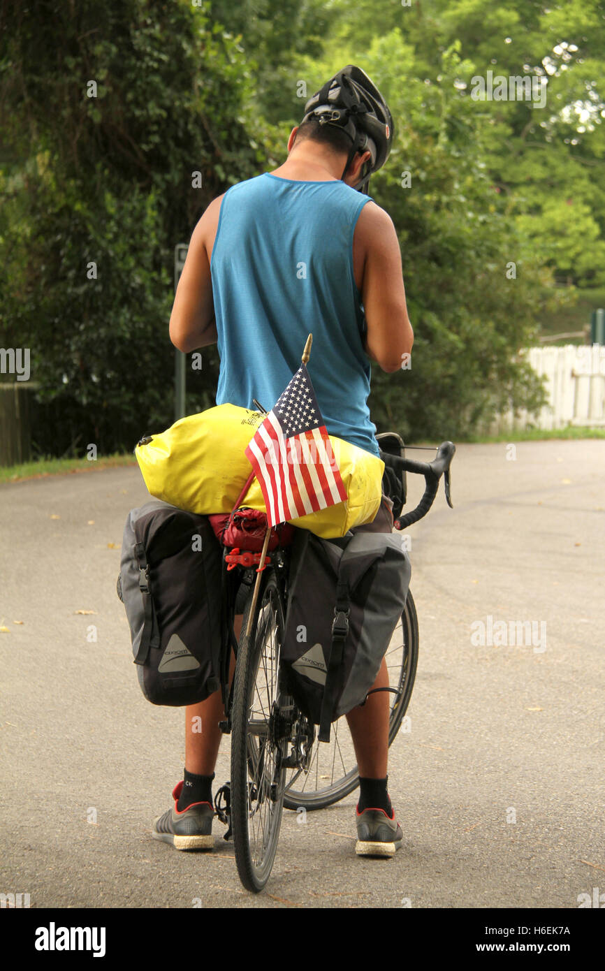 View from back of man traveling by bike, with American flag on bicycle ...