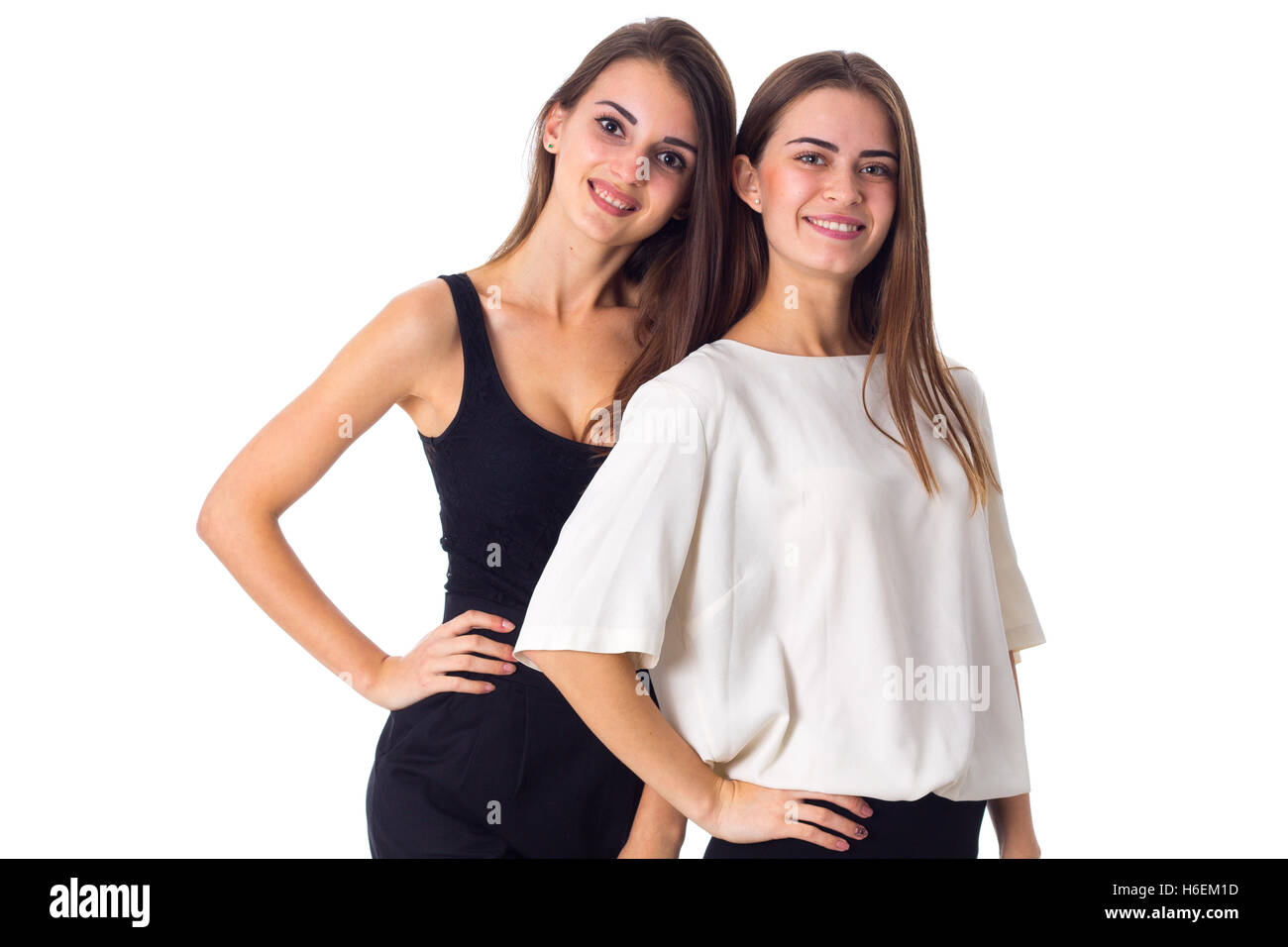 Two young woman standing and smiling Stock Photo - Alamy