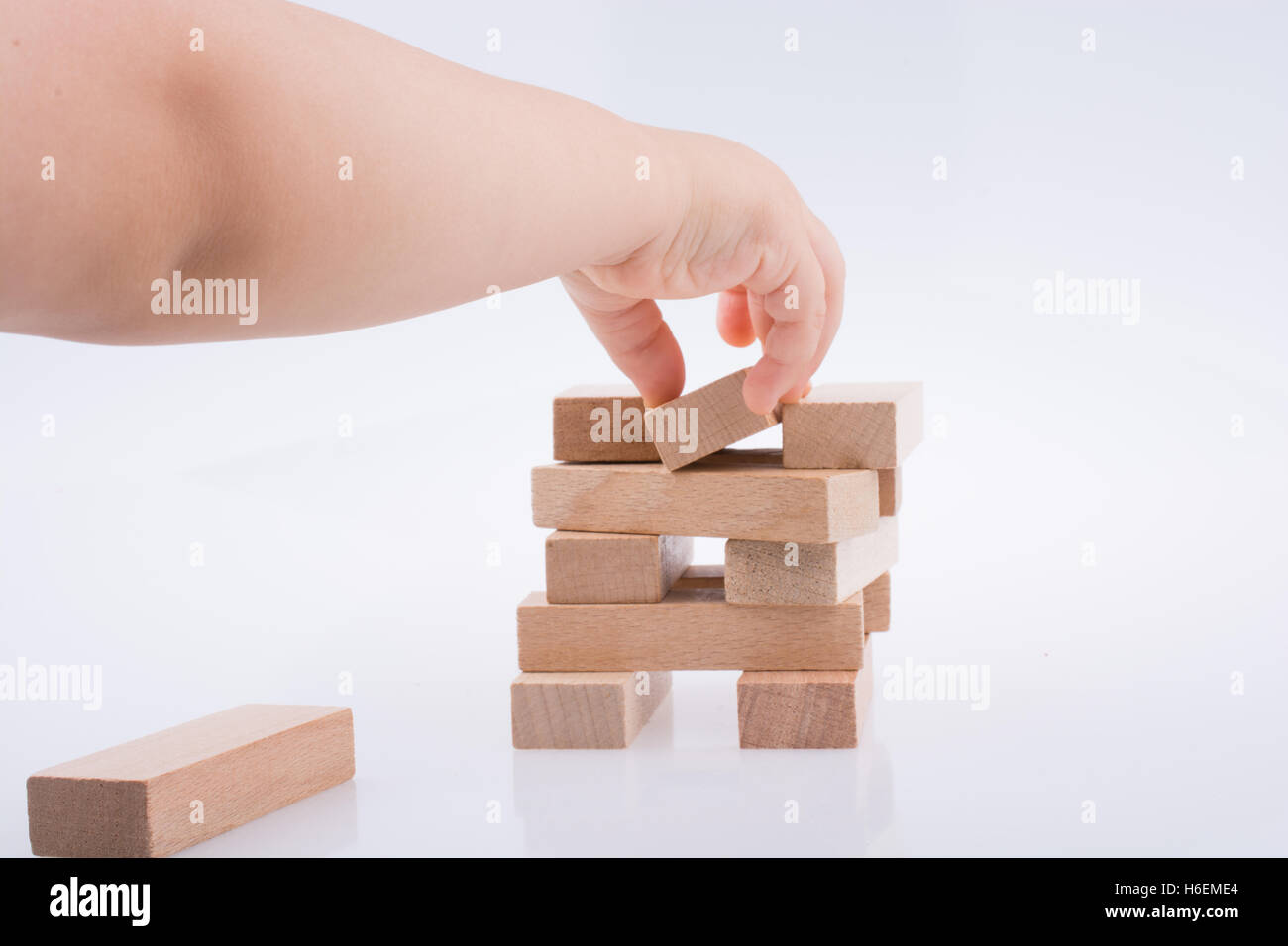 Hand playing with wooden building blocks on white background Stock ...