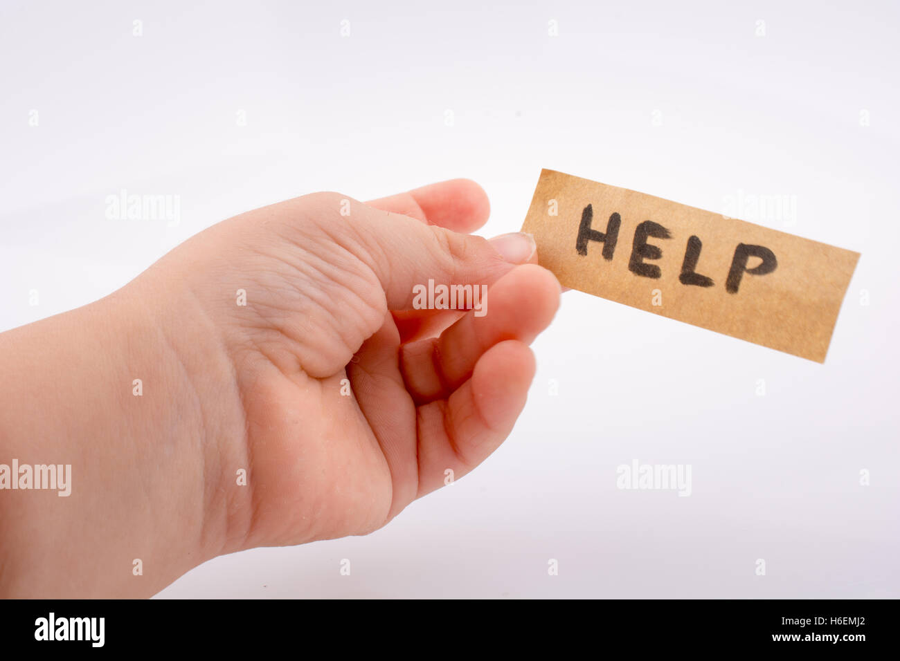 Help word on a piece paper in hand Stock Photo - Alamy