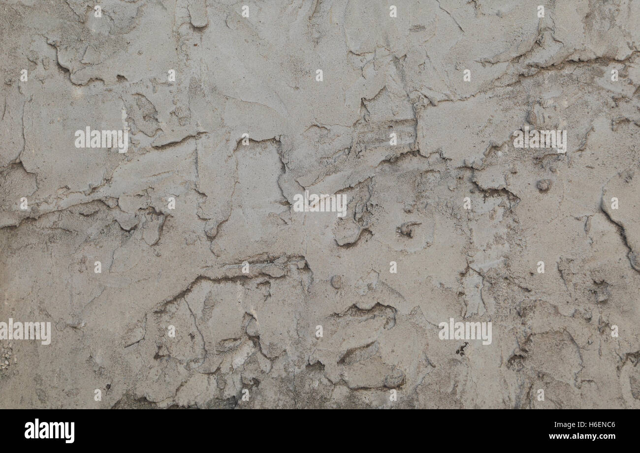 Crumbling grey plaster wall forms an irregular pattern that can be used ...