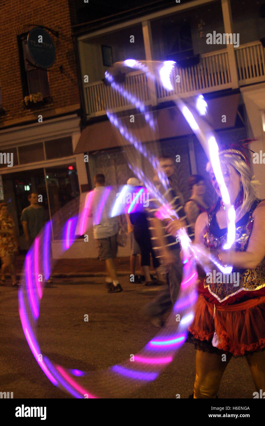 Young girl performing with glowing hula hoops on street at night Stock ...