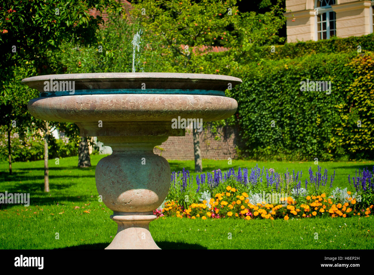 Bavaria, Germany - Classic stone fountain and colorful flowerbeds in ...