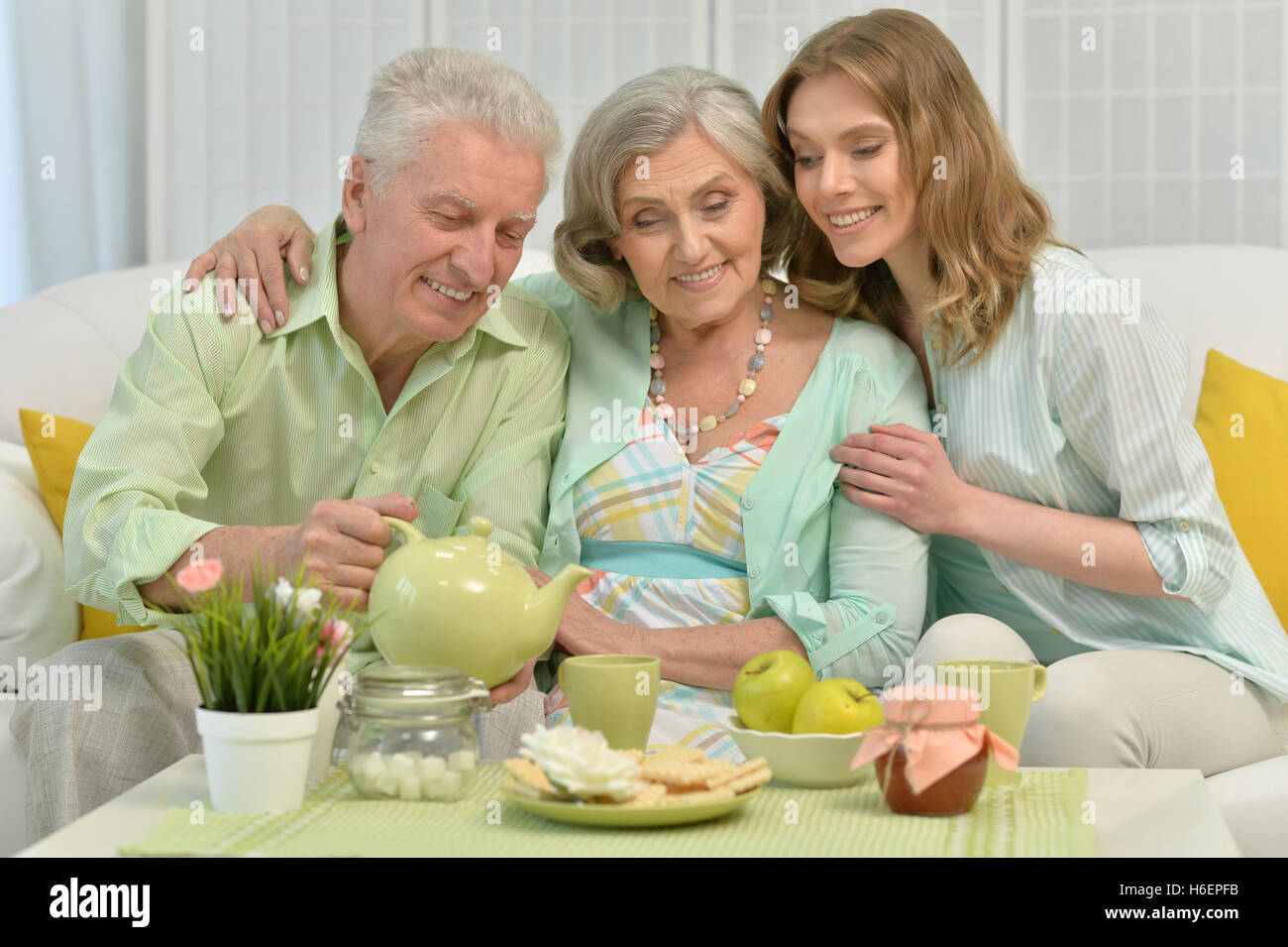 daughter with senior parents drinking tea Stock Photo - Alamy
