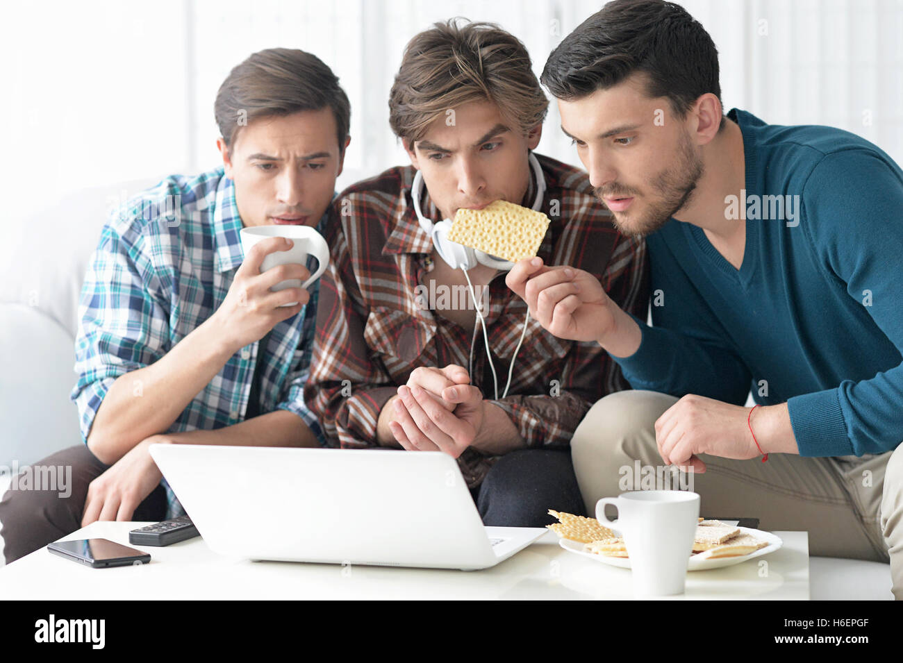 men watching video on laptop Stock Photo - Alamy