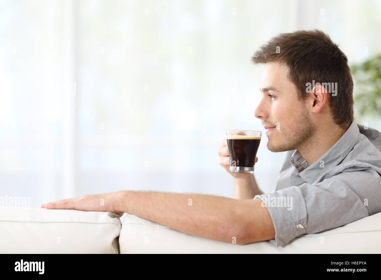 Profile portrait of a handsome man enjoying a cup of coffee relaxing ...