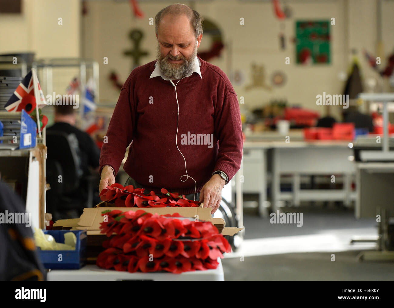 A worker puts a completed poppy wreath into a box at a Poppy Factory in ...
