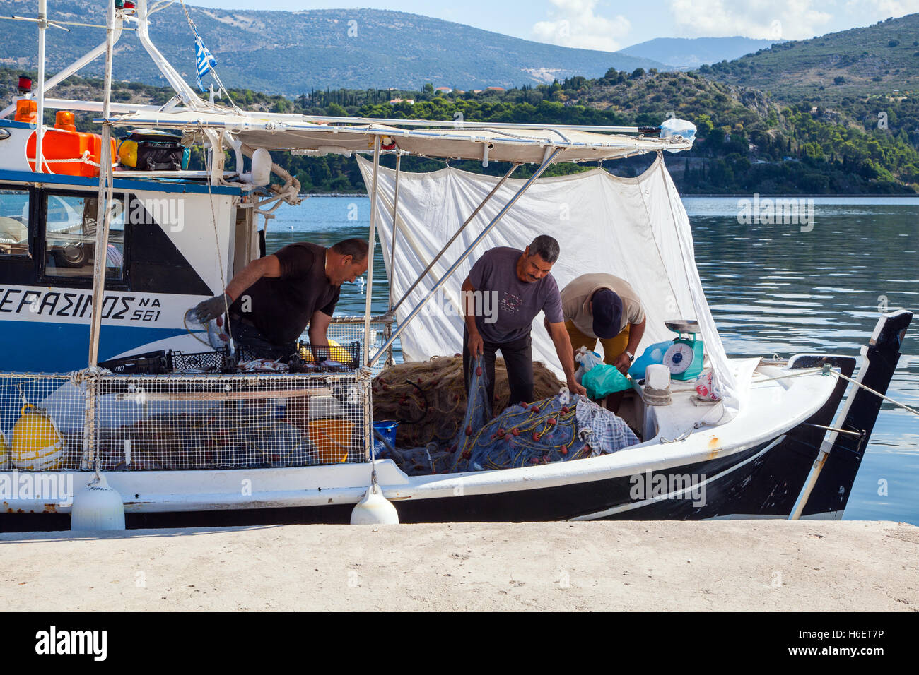 Fishermen and fishing boats in the harbour at Argostoli on the Greek ...