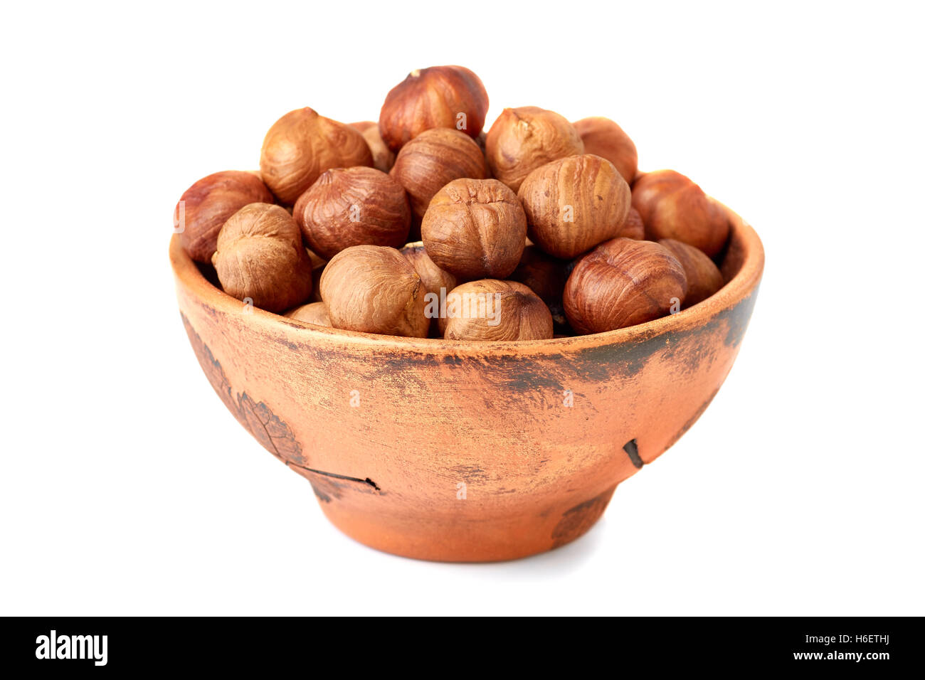 Ceramic bowl of hazelnuts on white Stock Photo - Alamy