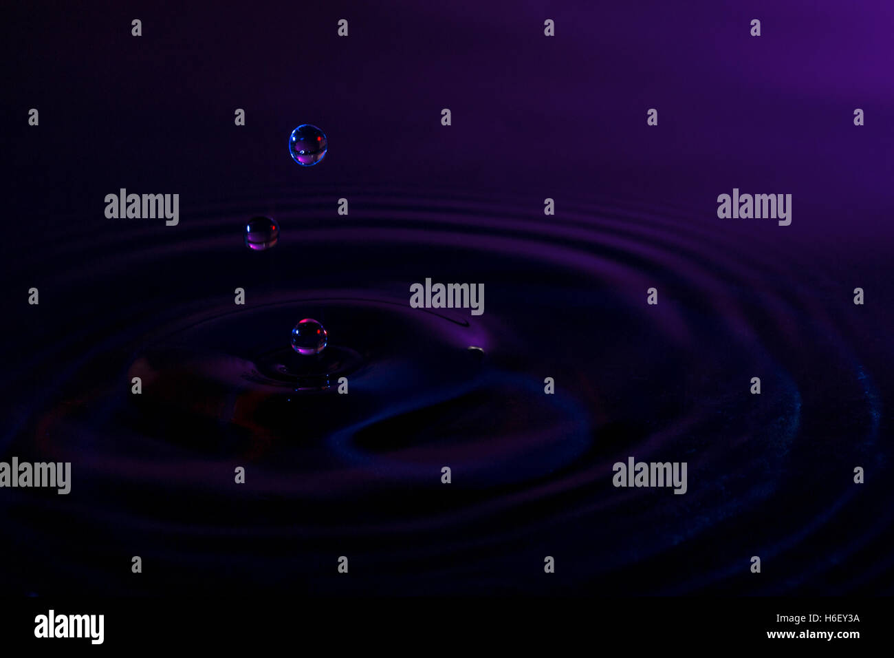 droplets fall into water in the dark Stock Photo - Alamy