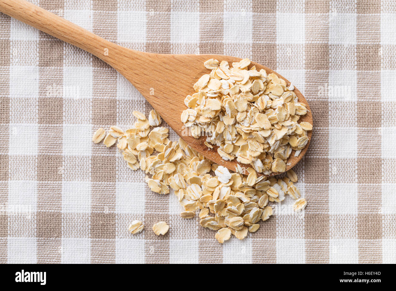 Dry rolled oatmeal in wooden spoon. Top view Stock Photo - Alamy