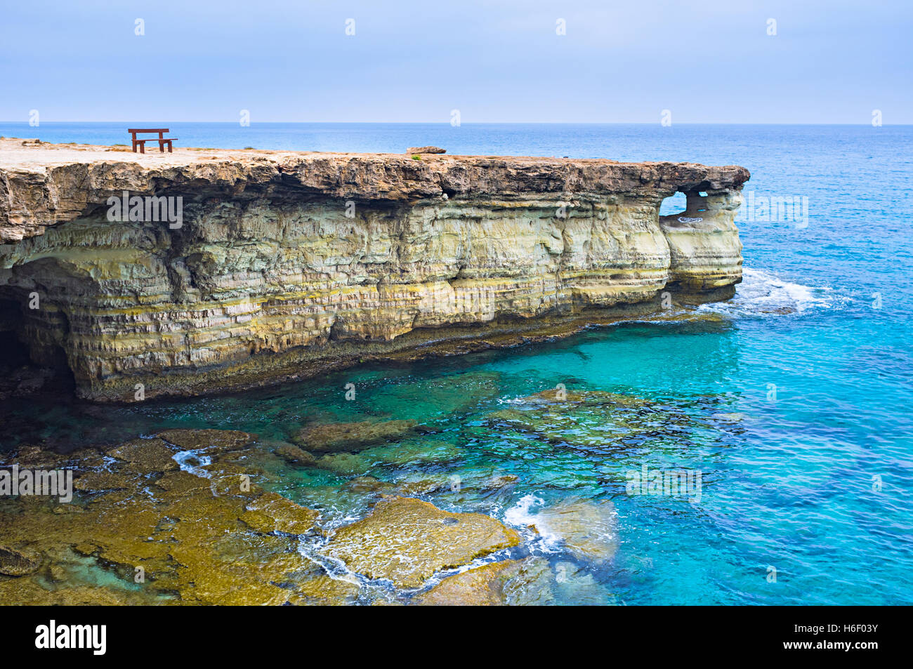 The seashore with many sharp stones and scenic white cliff with the ...