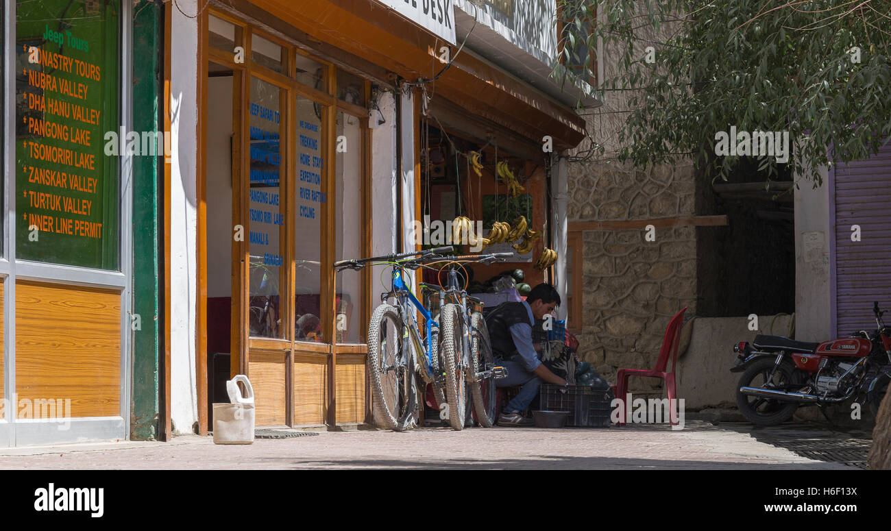 Shopkeeper sits outside his shop in the backstreets of Leh Stock Photo ...