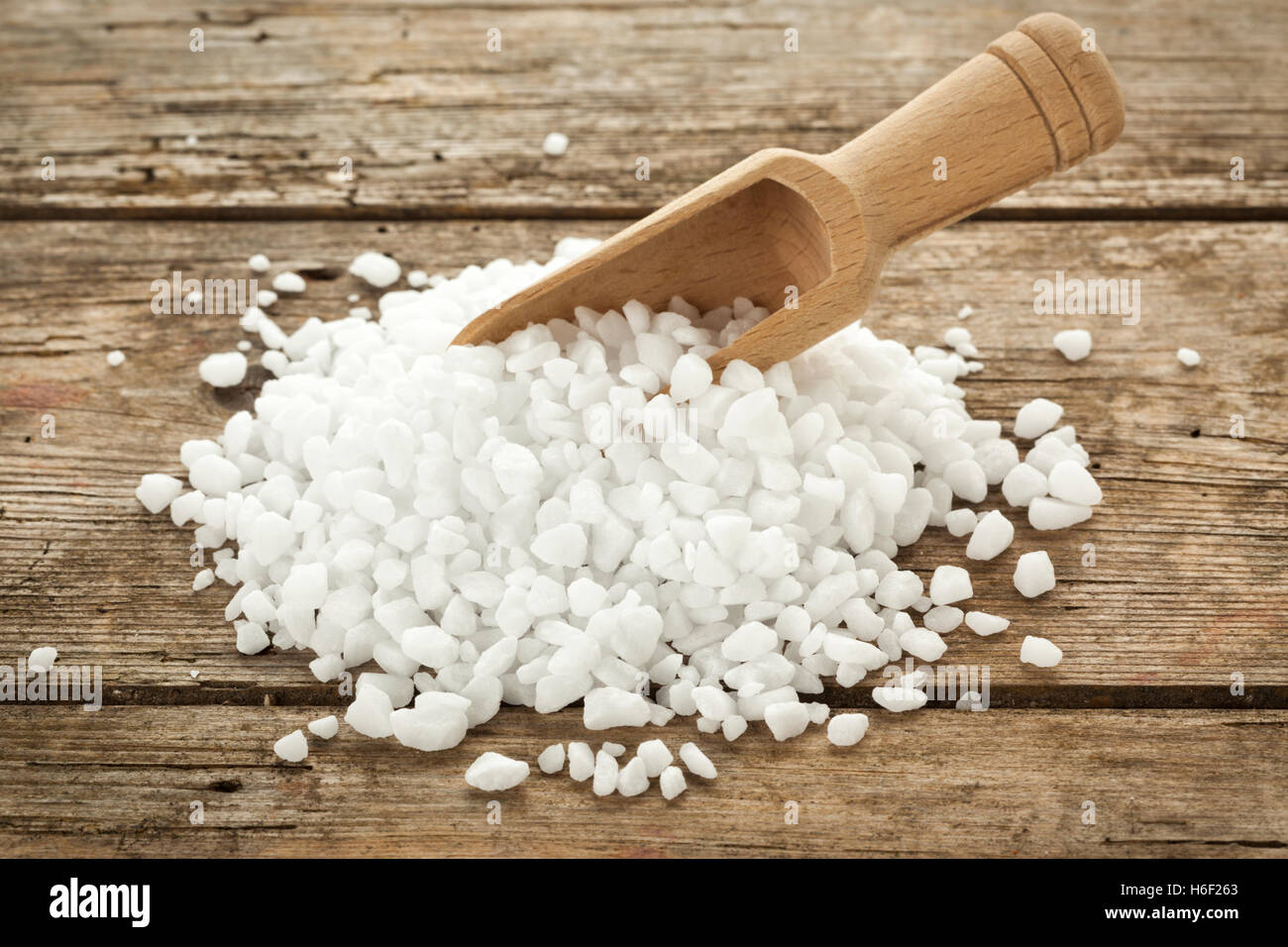 Heap of coarse salt with wooden scoop on rustic table, closeup Stock ...
