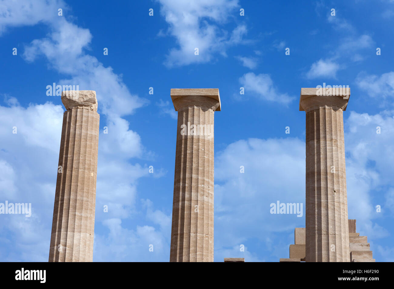 Ancient Greek pillars at the Athens acropolis with blue cloudy sky in ...