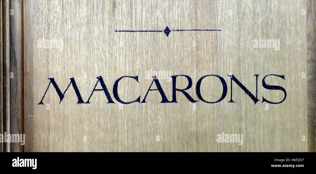 Macarons sign on French patisserie in Paris. Wood panel and blue ...