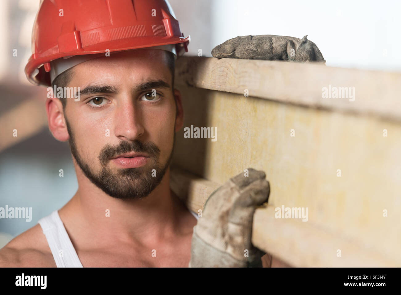 Smiling Carpenter Carrying A Large Wood Plank On His Shoulder Stock ...