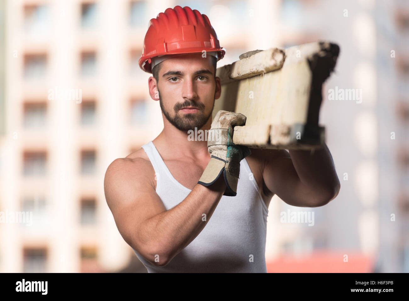 Smiling Carpenter Carrying A Large Wood Plank On His Shoulder Stock ...