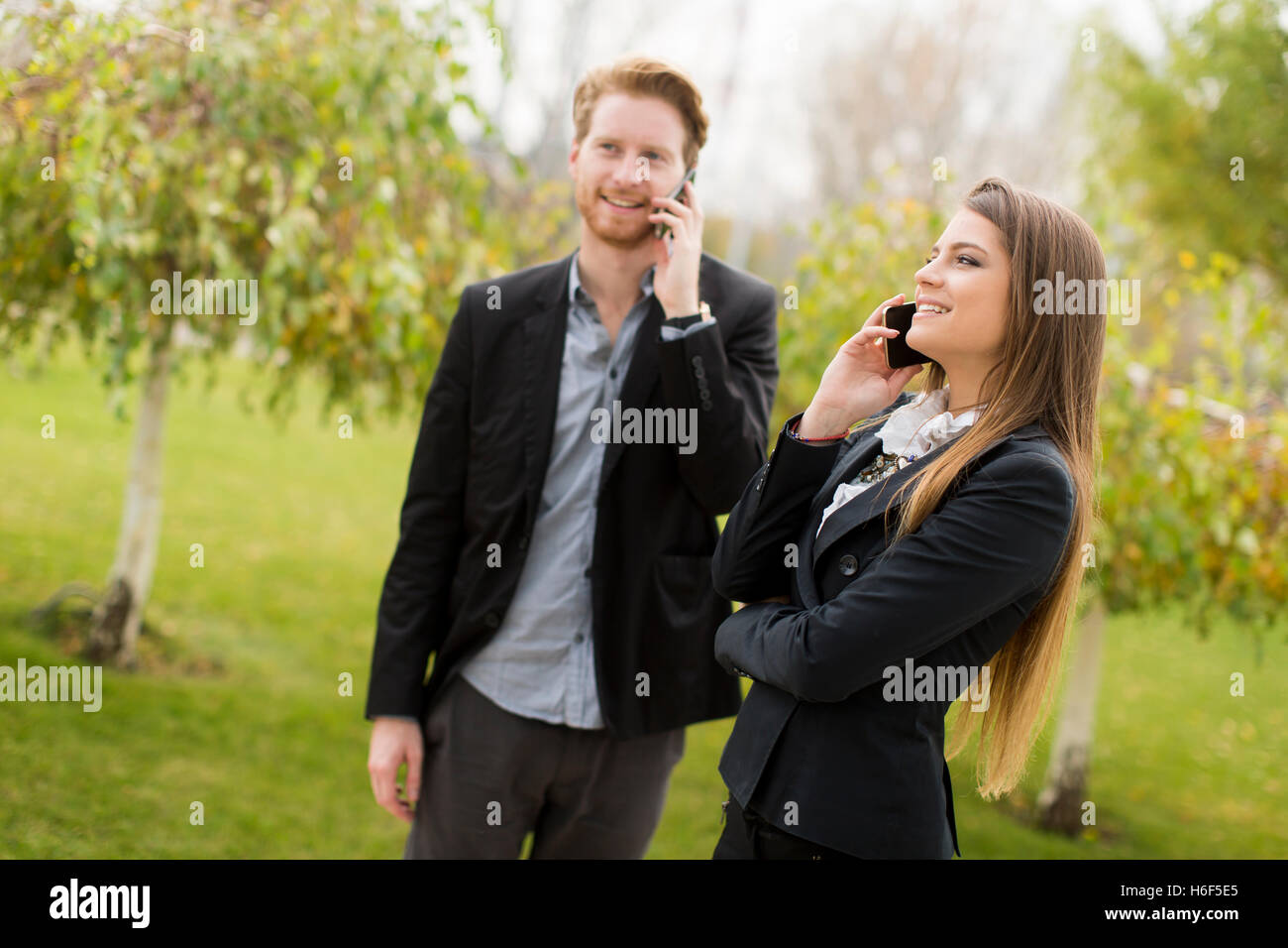 Young business people on their phones outside Stock Photo - Alamy