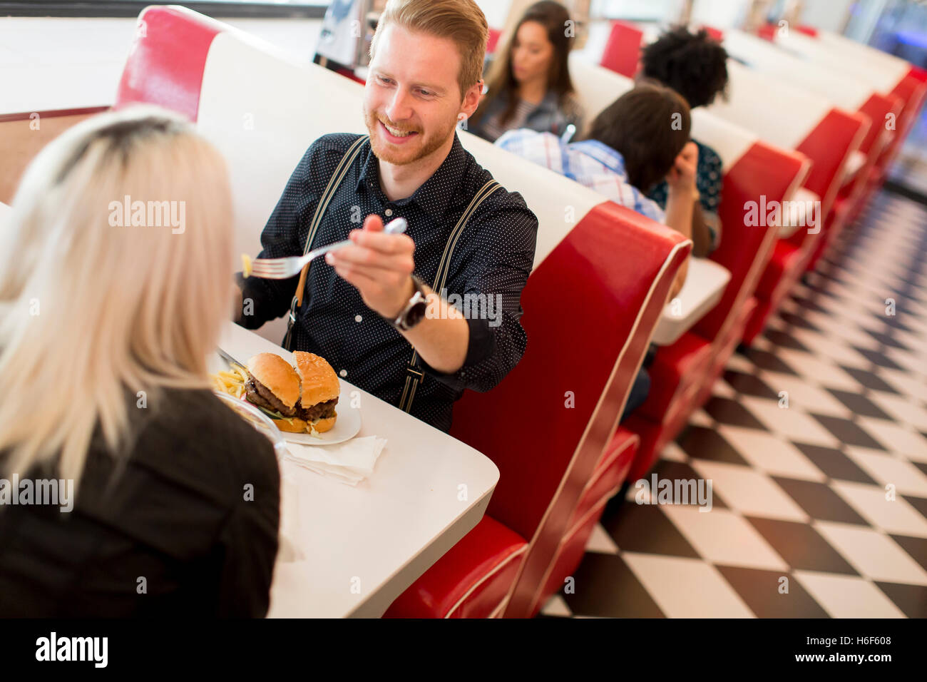 Friends eating fast food at the table in the diner Stock Photo - Alamy