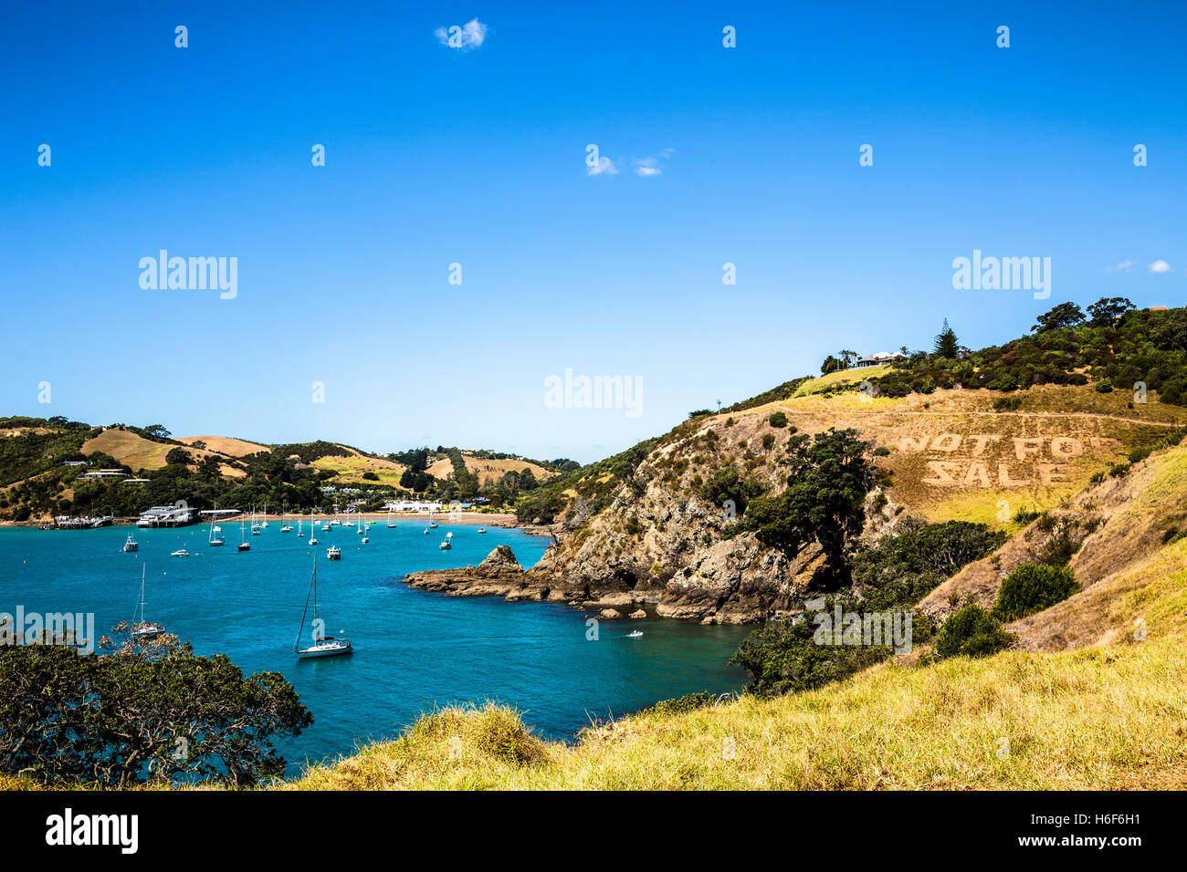 The harbor and surrounding cliffs of Waiheke Island near Auckland, New ...