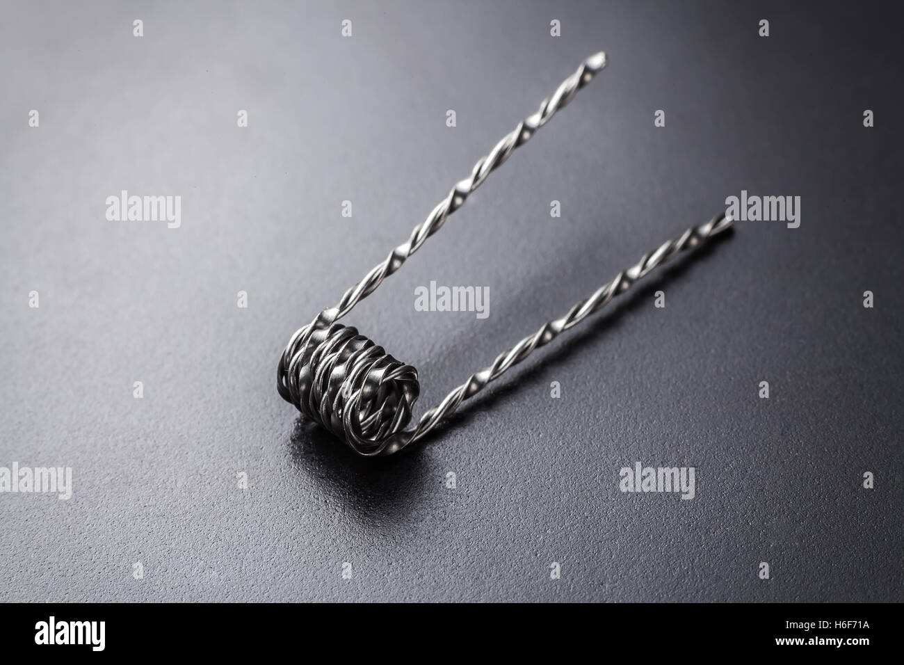 Mix twisted coil for vaping on a black background macro closeup wire ...