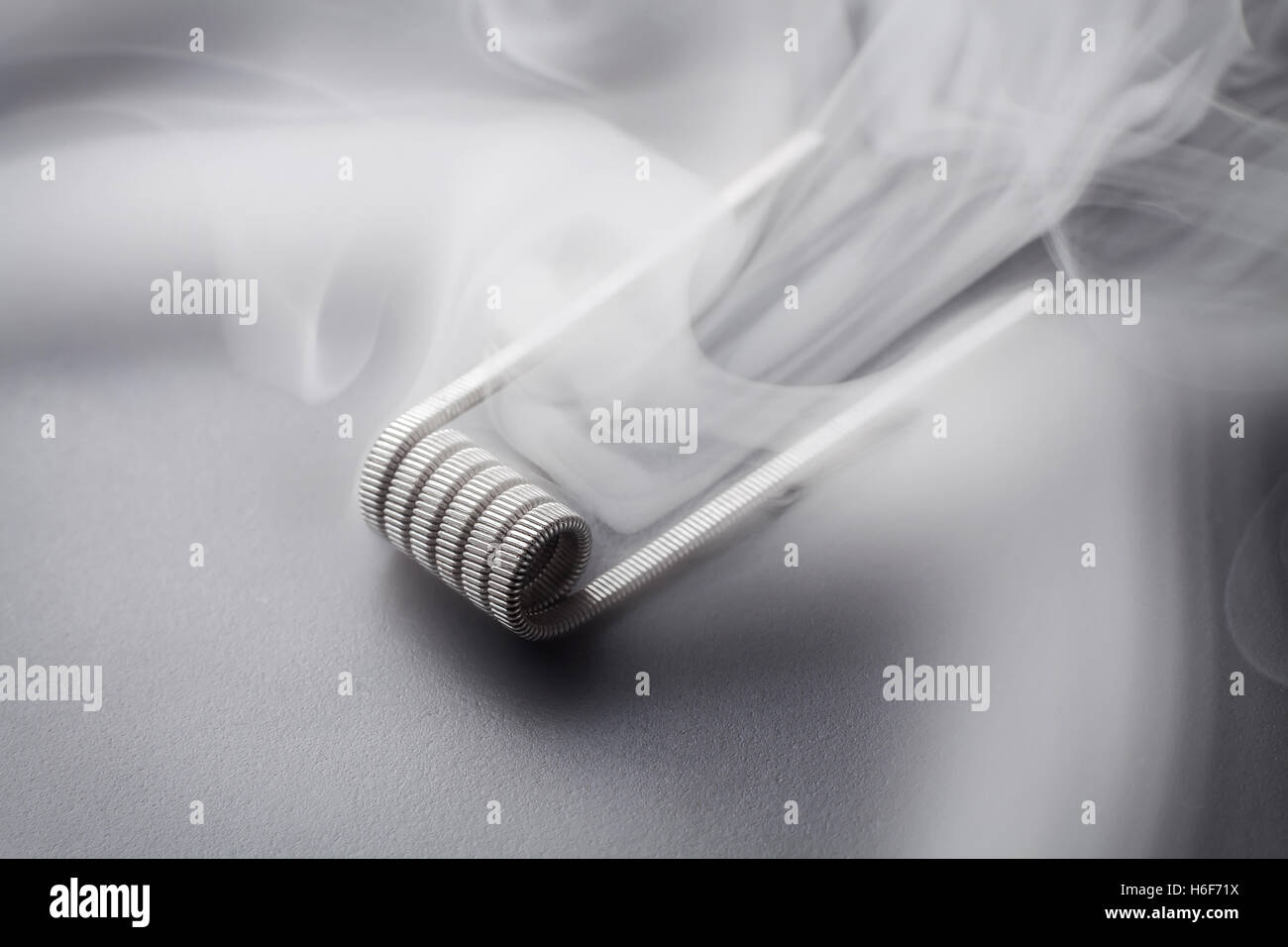 Tank track coil for vaping on a black background macro smoke closeup ...