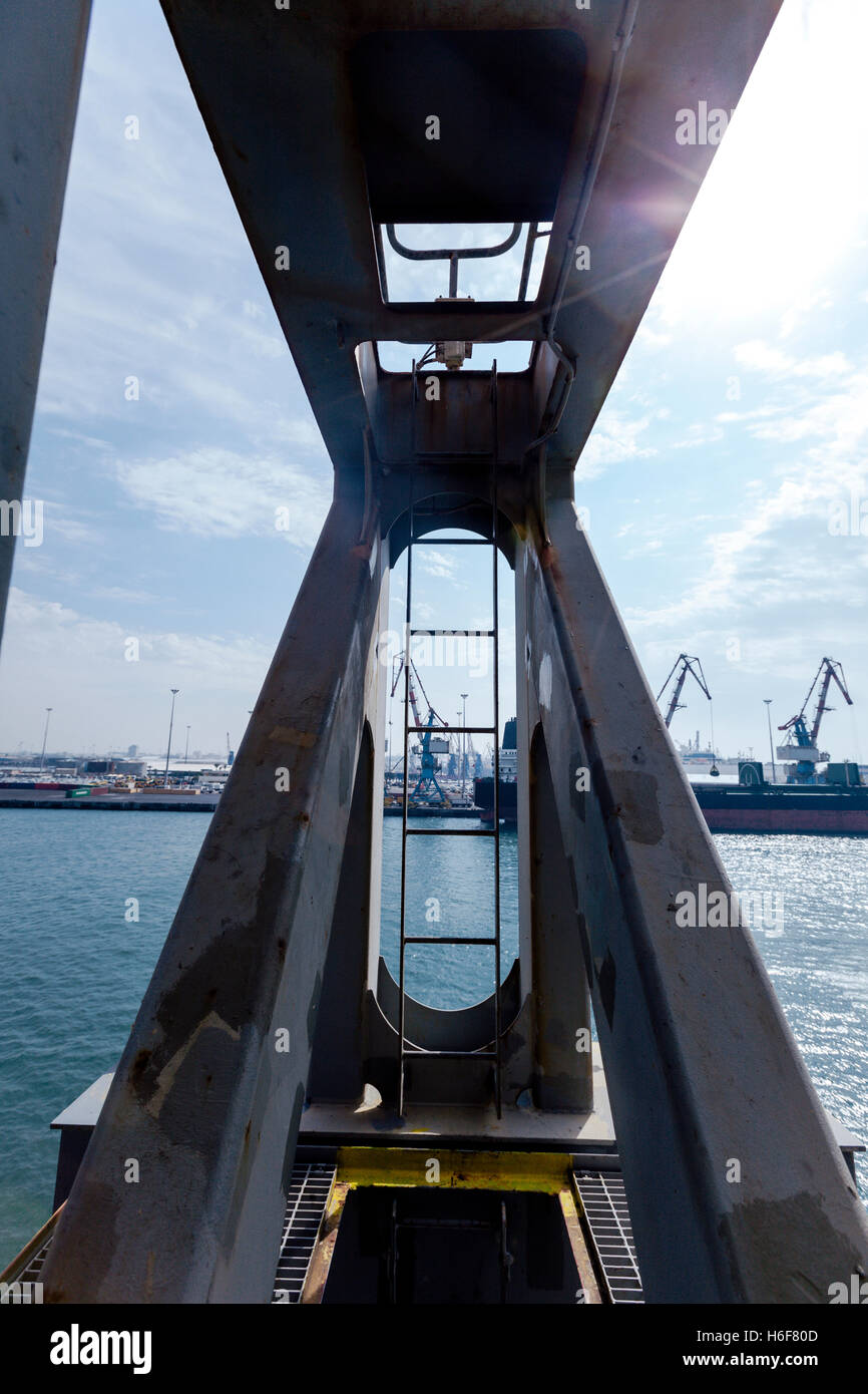 View of a commercial harbor as seen through a detail of a freighter ...