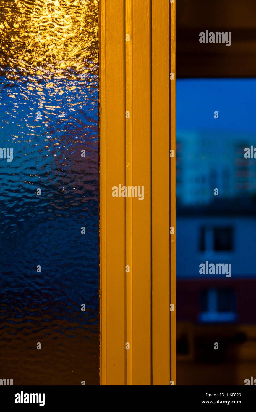 Tungsten lighting reflecting off a bumpy window, with another window in ...