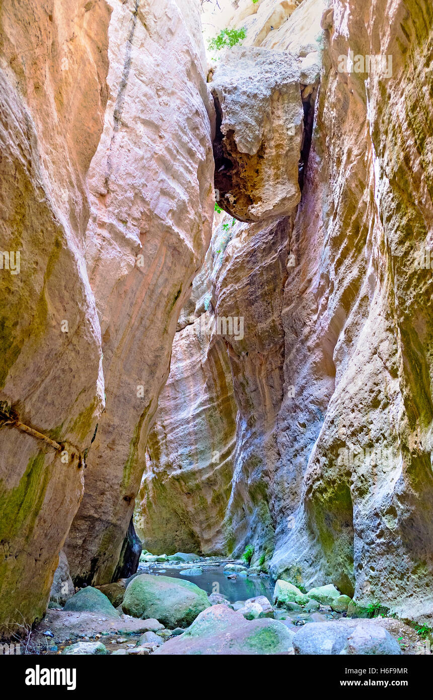 The huge boulder, sandwiched between two rocks, hangs over the narrow ...