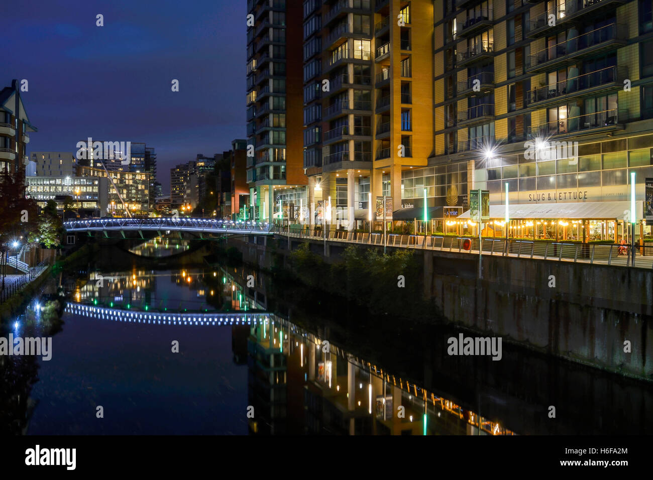 Illuminated footbridge crossing the River Irwell joining Spinningfields ...