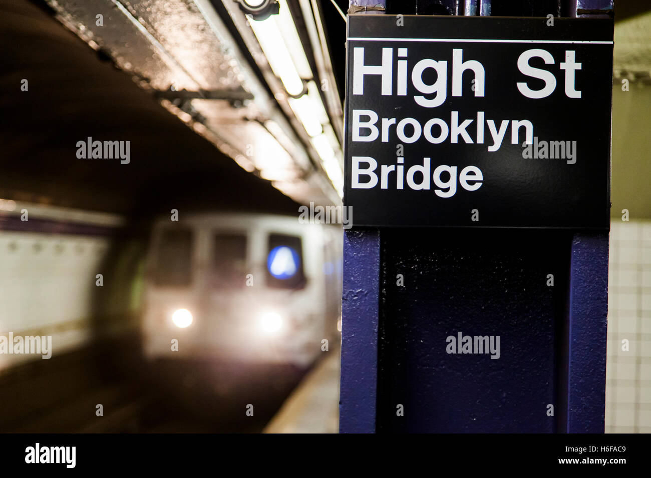 Subway train approaching behind the sign depicting it's the High St ...