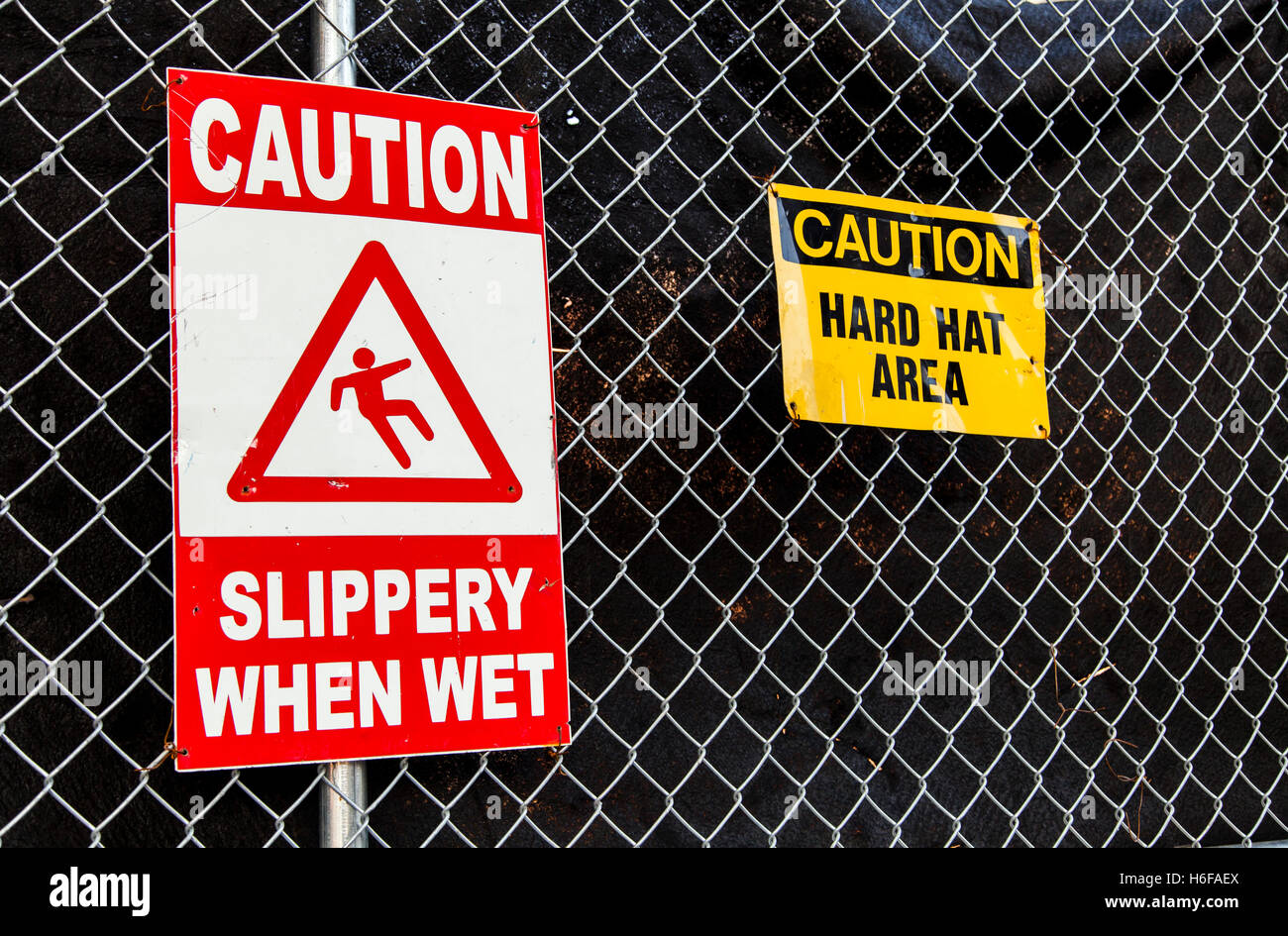 Two warning signs on a wire mesh fence of a construction site Stock ...