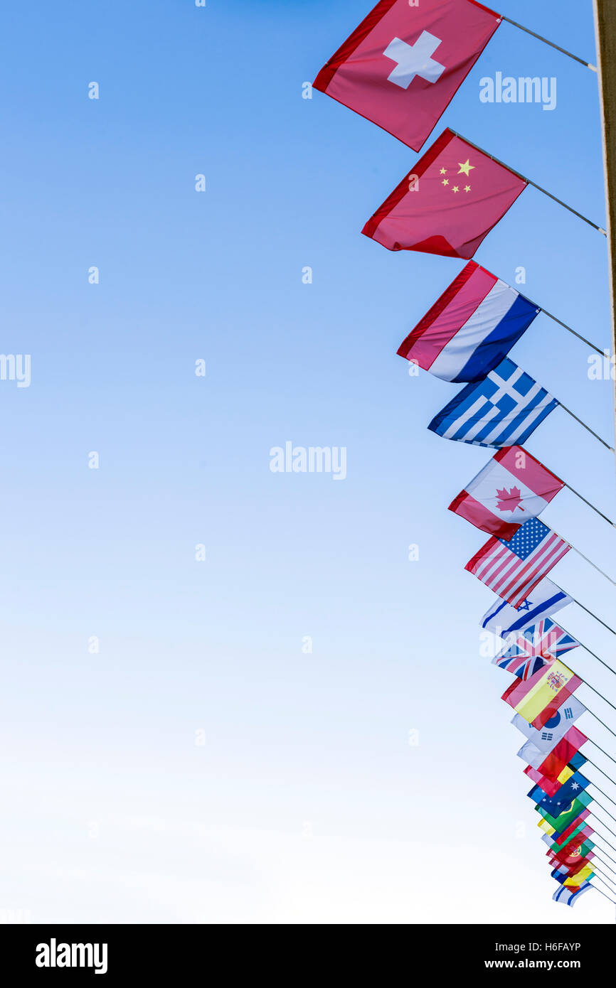 A row of many national flags of various nations fluttering in the wind ...