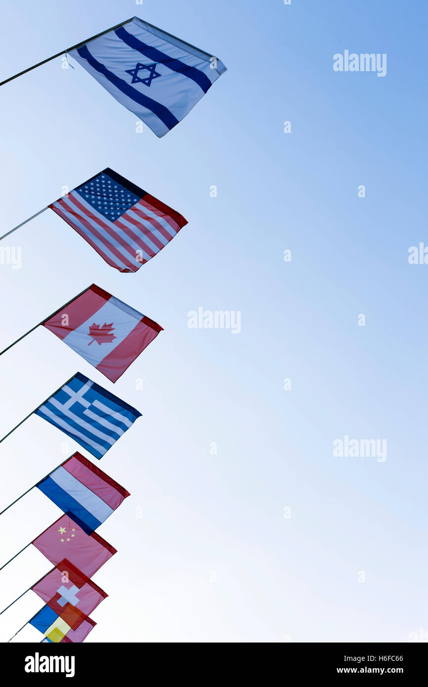 A row of many national flags of various nations fluttering in the wind ...