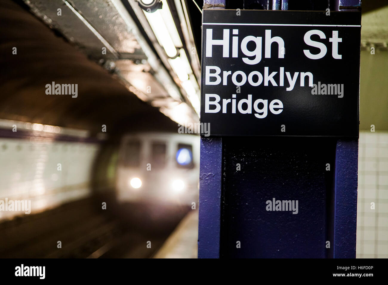 Subway train approaching behind the sign depicting it's the High St ...