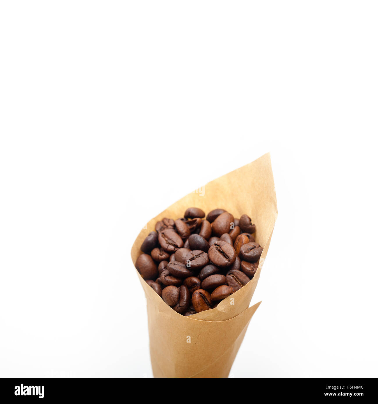 espresso coffee beans on a paper cone cornucopia over white background ...