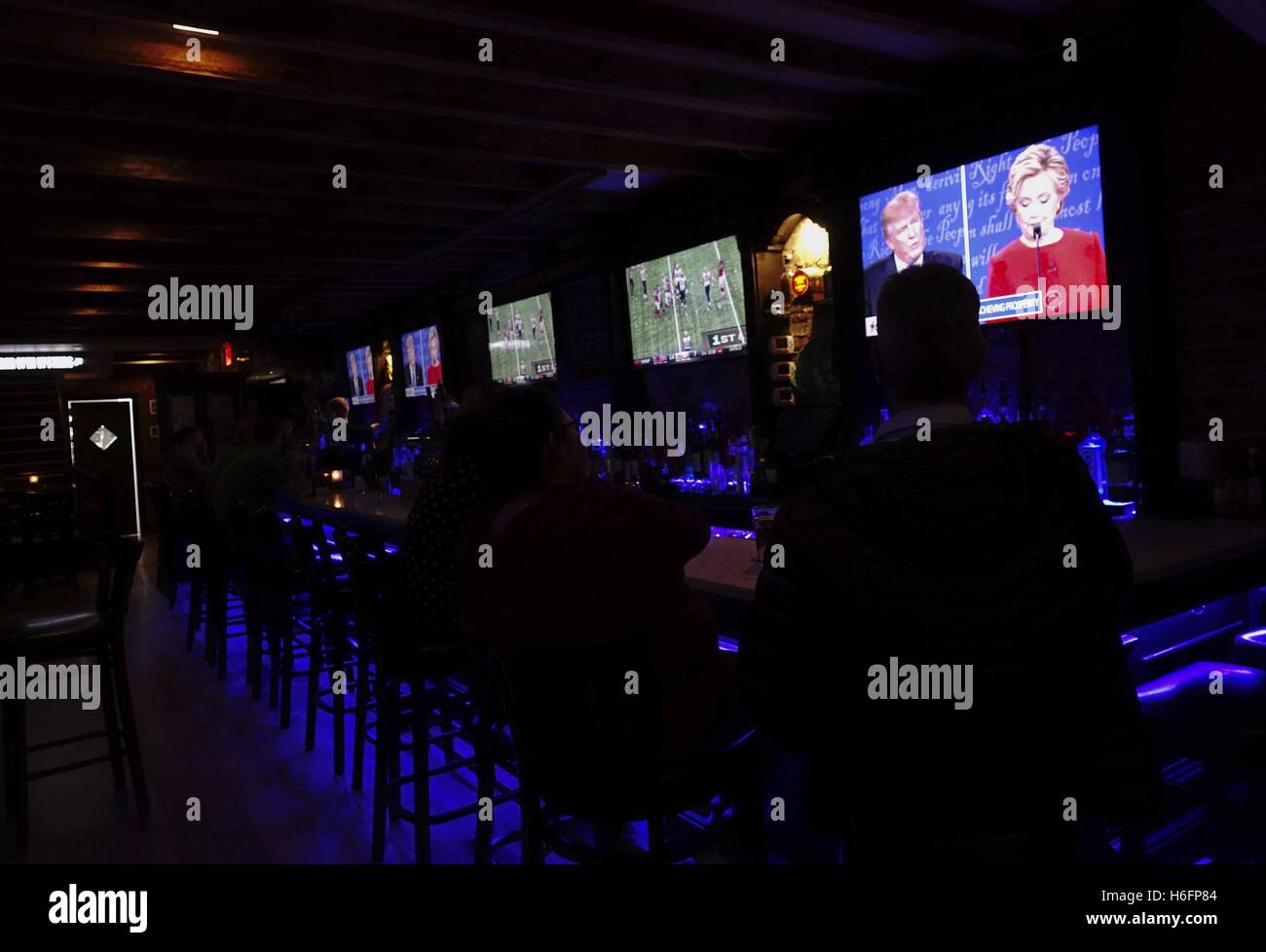 People in a New York bar watch the first US presidential debate on TV ...