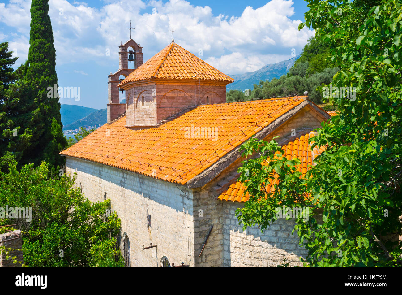 The red tile roof of the Holy Trinity Church with the mountains on the ...
