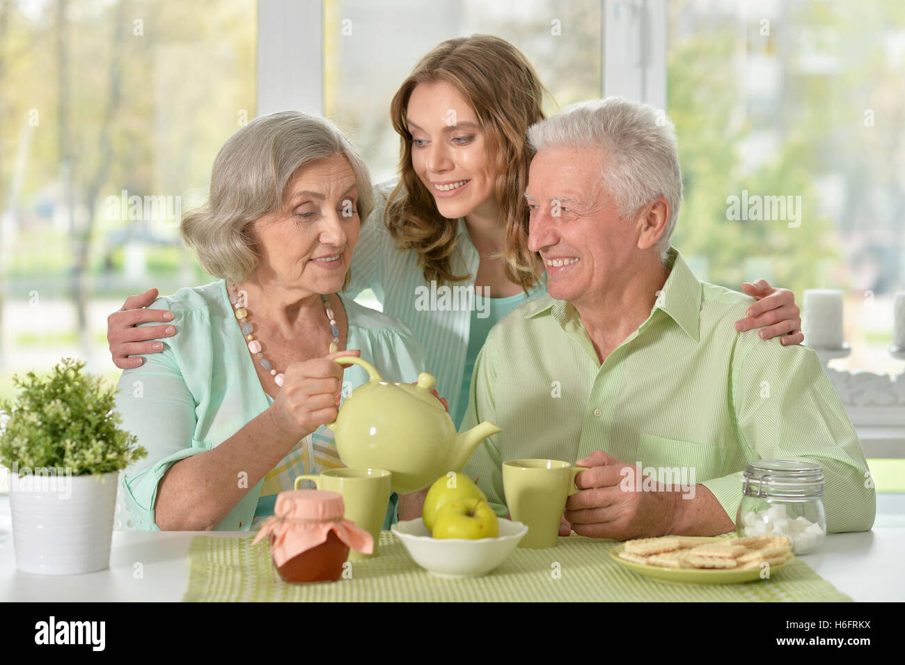 daughter with senior parents drinking tea Stock Photo - Alamy