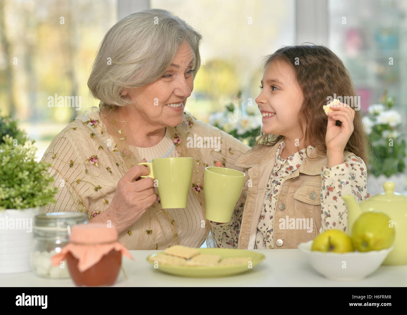 Old woman with girl drinking tea Stock Photo - Alamy