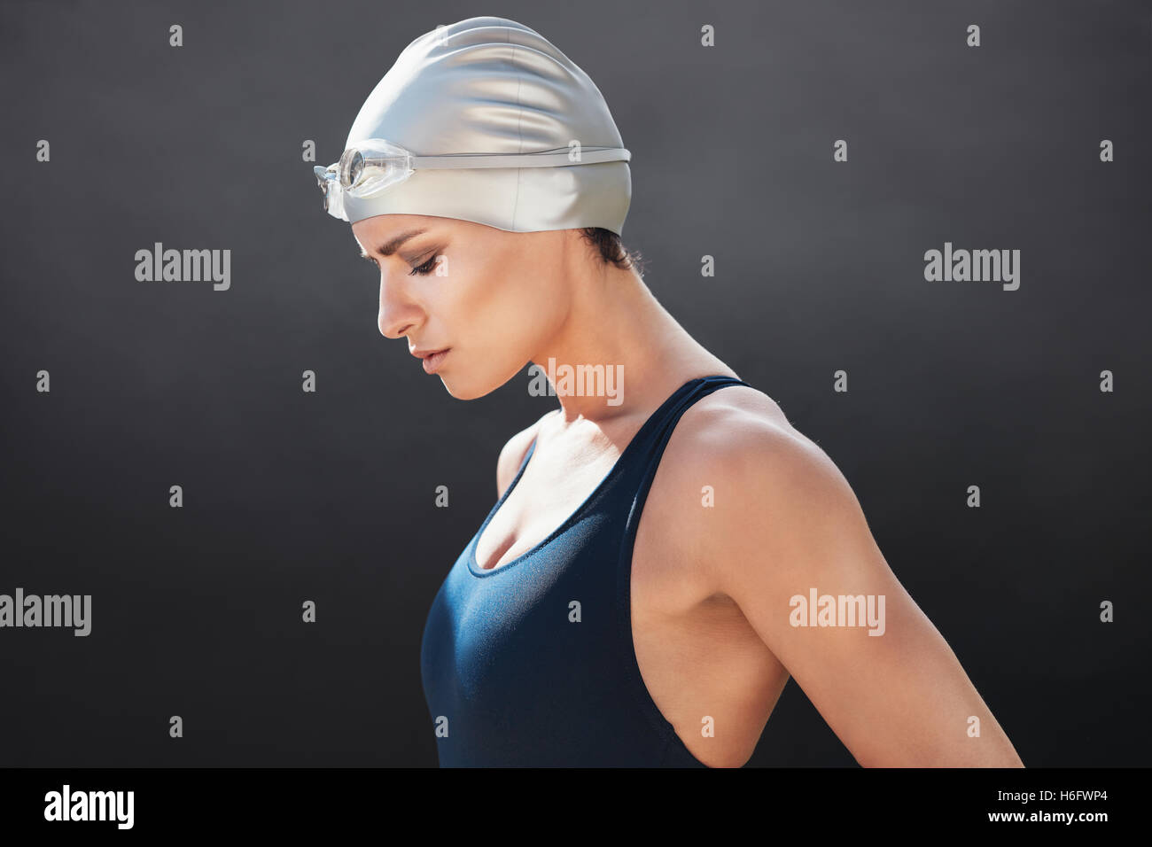 Side view of fit young female swimmer on black background. Fitness ...