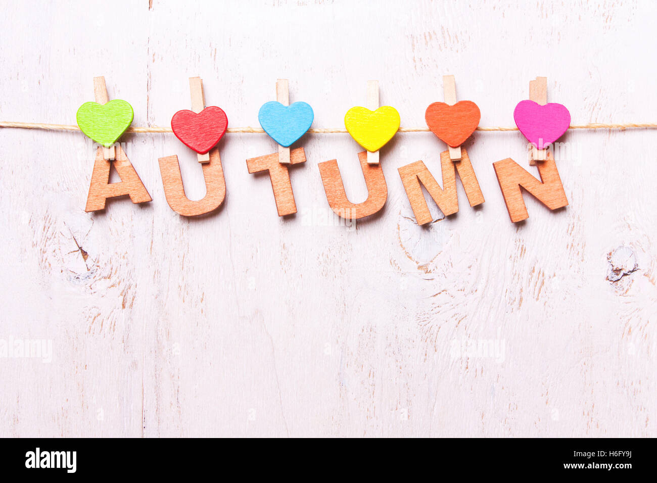 the word "autumn" from the wooden letters on a white background old ...