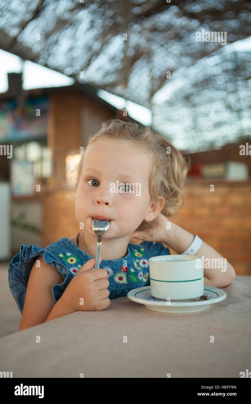 pretty little girl drinking tea from a cup Stock Photo - Alamy