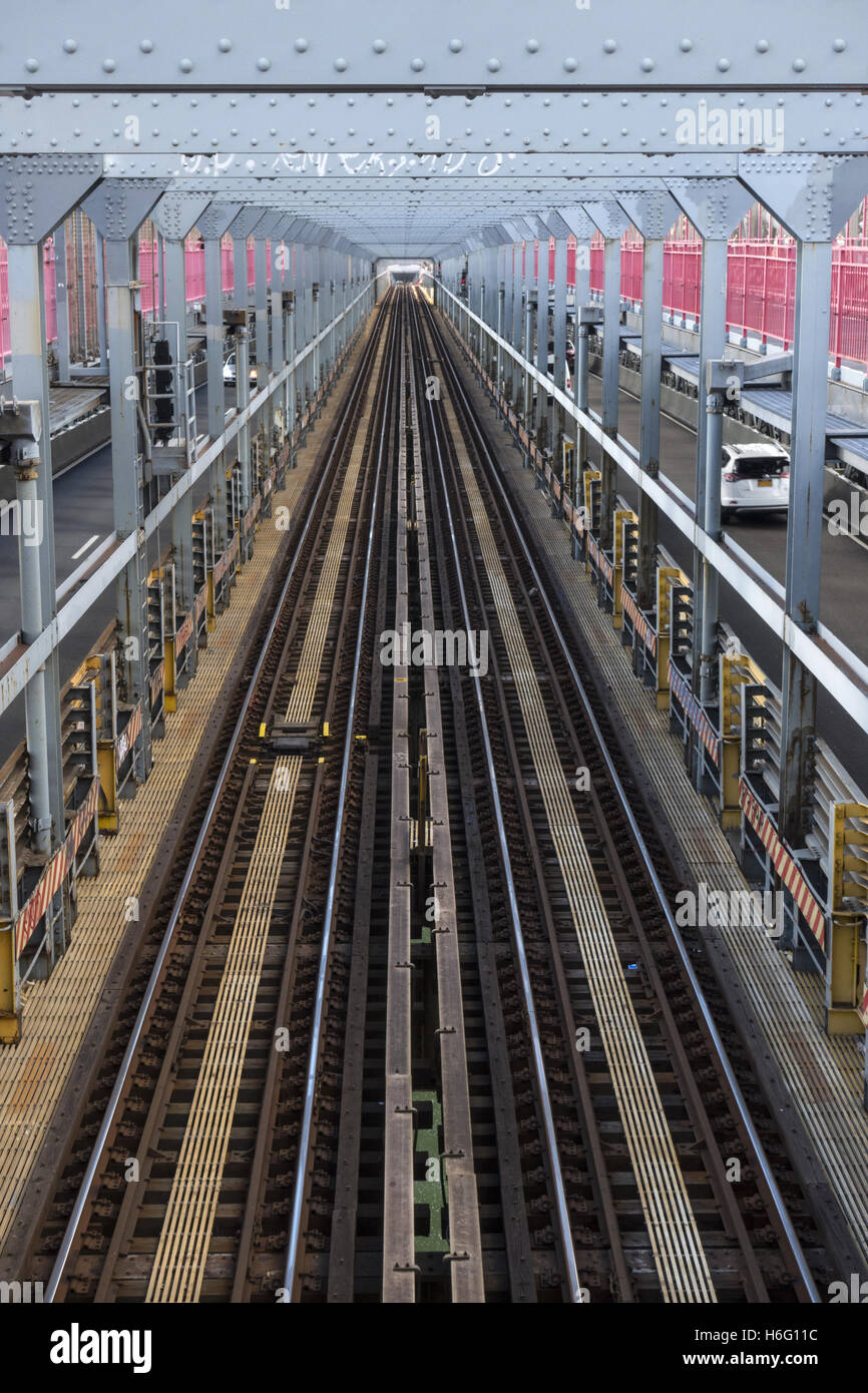 the J Train along with cars and pedestrians travels over the Williamsburg Bridge between ...
