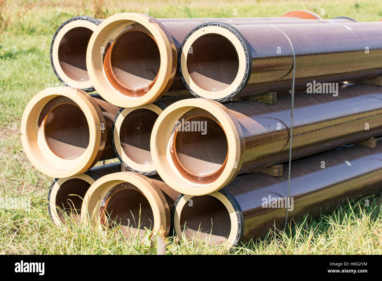Stack of canalization pipes at a construction site Stock Photo - Alamy