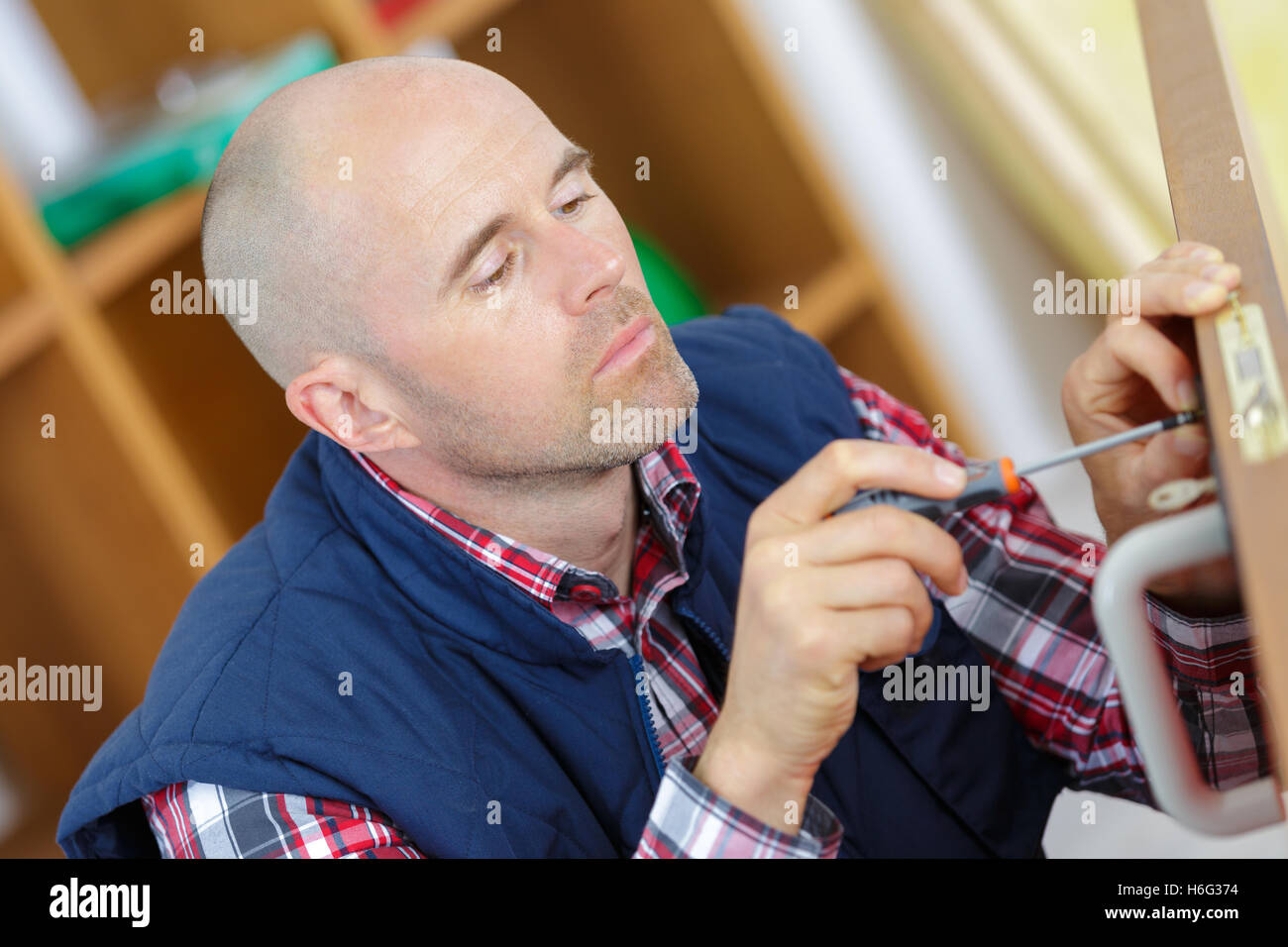 young man fixing the door with screwdriver Stock Photo - Alamy